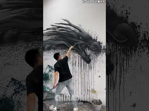 Artist paints a dragon on the wall