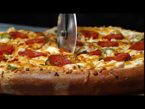 Cutting through a fresh pizza Free Stock Video Mixkit