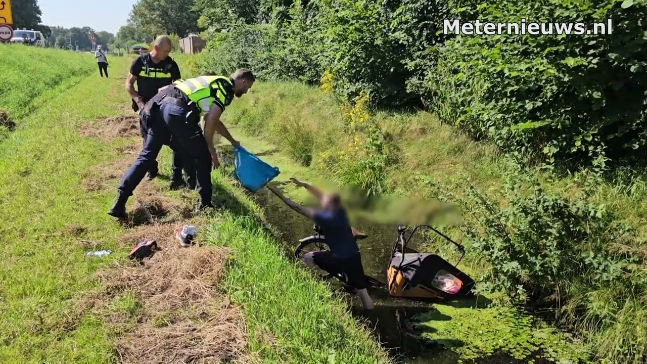 Man en kind met bakfiets van talud en de sloot in De Wijk(Video)