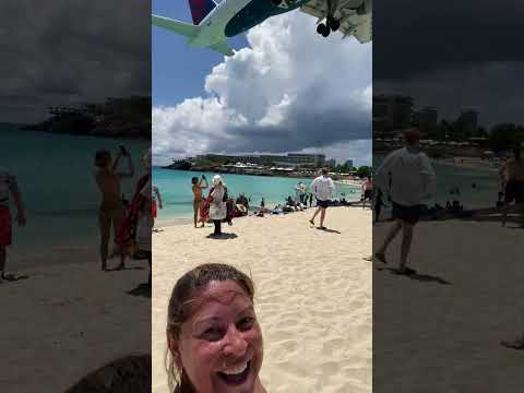 Airplane Passing Over Beach Goers to Land in a Nearby Airport