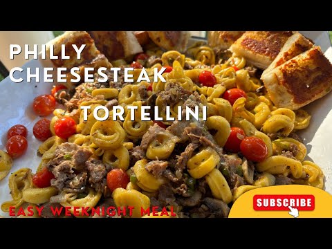 Philly cheesesteak tortellini with cheesy garlic bread on the blackstone