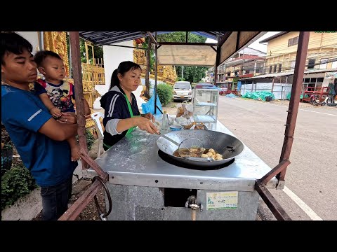 Family makes a living selling Lao donuts in front of Wat Sysavath in Vientiane, Laos.
