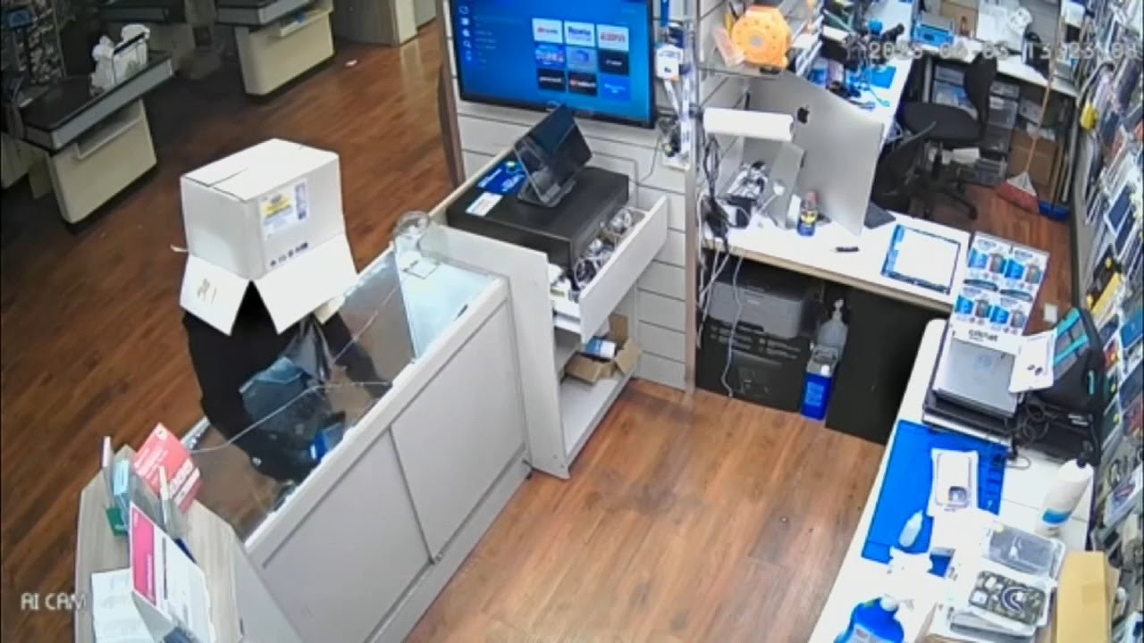 Man hides face with cardboard box during smash and grab at Florida phone store