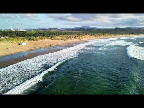 A breathtaking aerial view showcases a serene beach adorned with gentle waves and sunlit shores