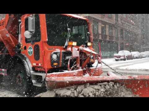 3 DSNY PLOWS & A SALT SPREADER MAKING A PASS ON AMSTERDAM AVENUE DURING WINTER SNOW NIKO IN NYC.