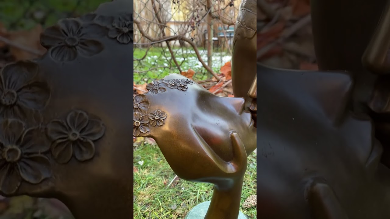 A BRONZE SCULPTURE OF TWO FACES KISSING