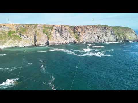 A stunning aerial view showcasing the beautiful coastal cliffs alongside crashing ocean waves