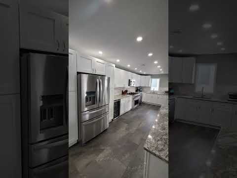 Galley Kitchen with White Shaker Cabinets, Vinyl Floor, Granite Countertops, Handcrafted Subway Tile